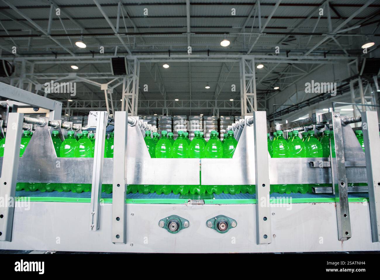 Bottling process of green soda drinks in a modern factory setting with ...