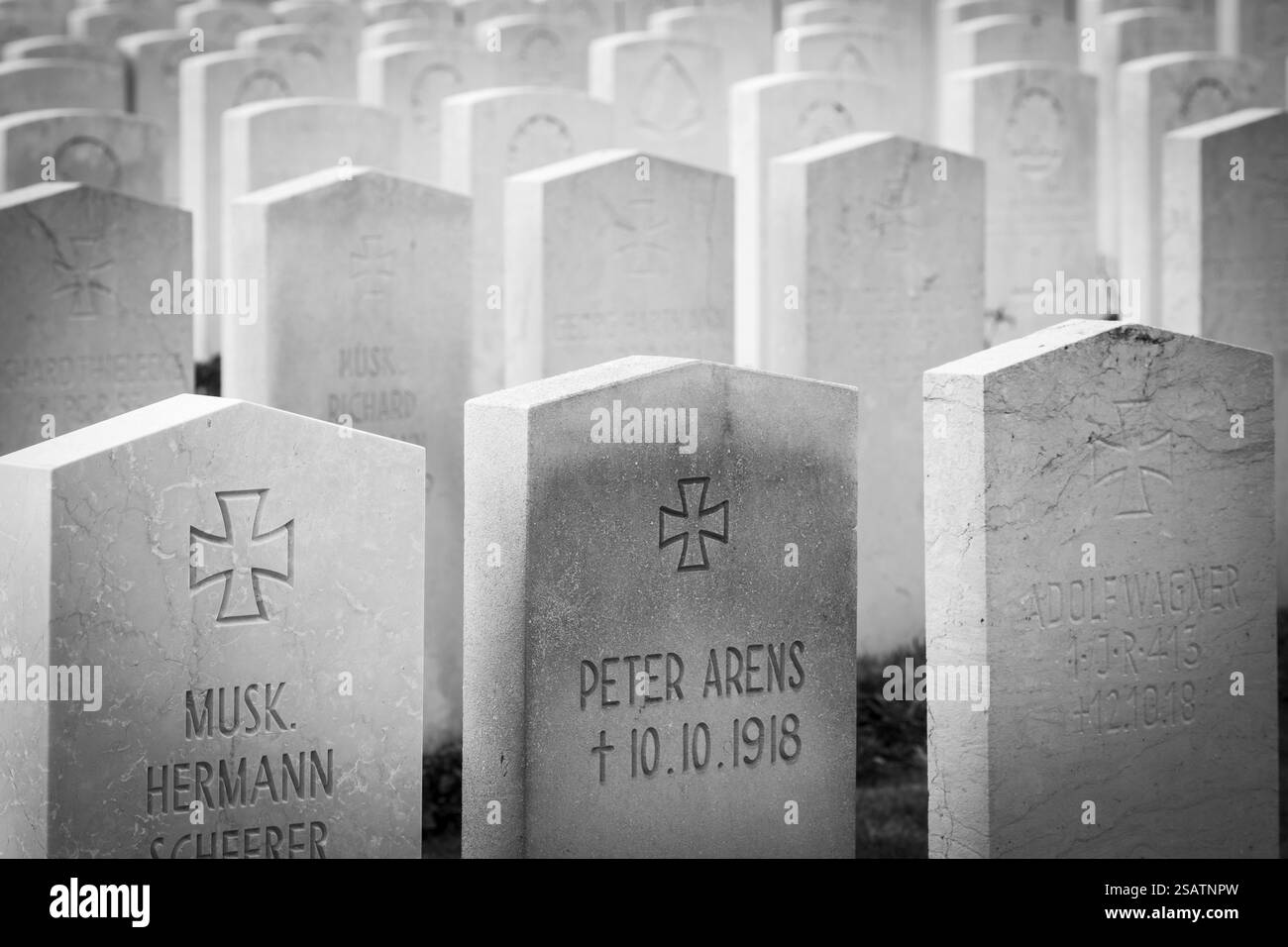 A black and white photo of a First World War military cemetery with rows of gravestones and ...