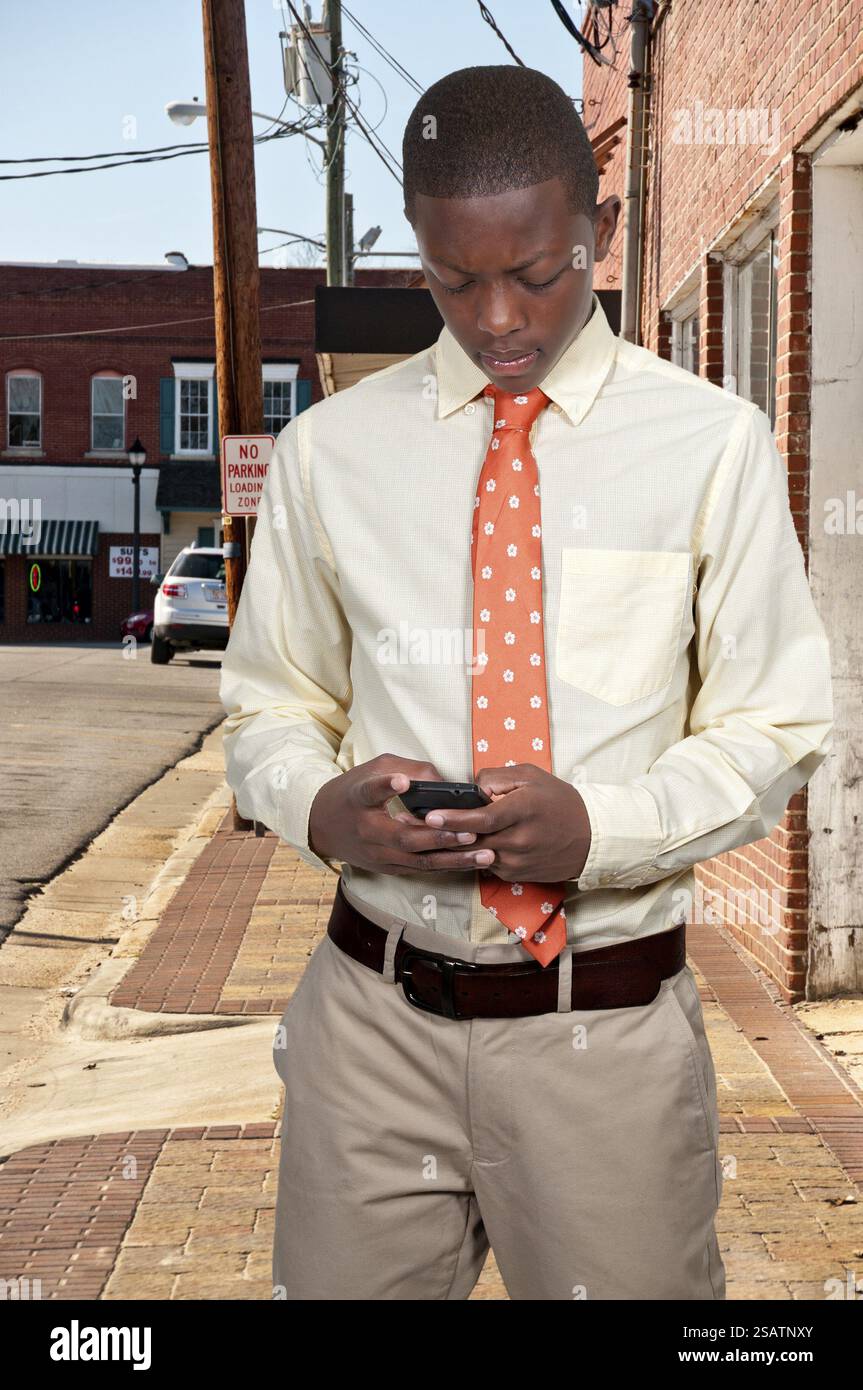 Black African American teenager man using a cell phone for texting ...