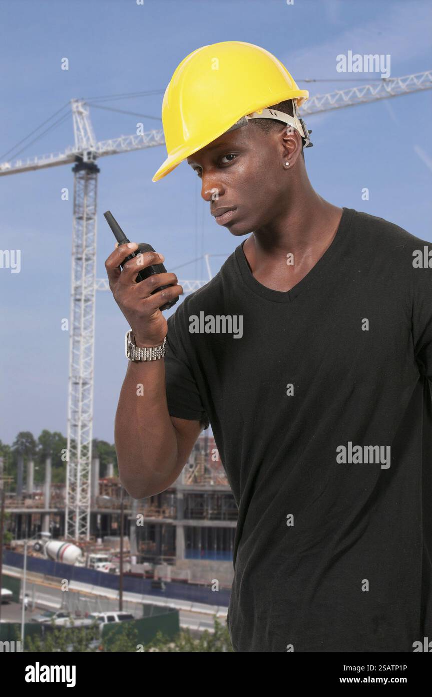 Handsome black man construction worker talking on a walkie talkie Stock ...