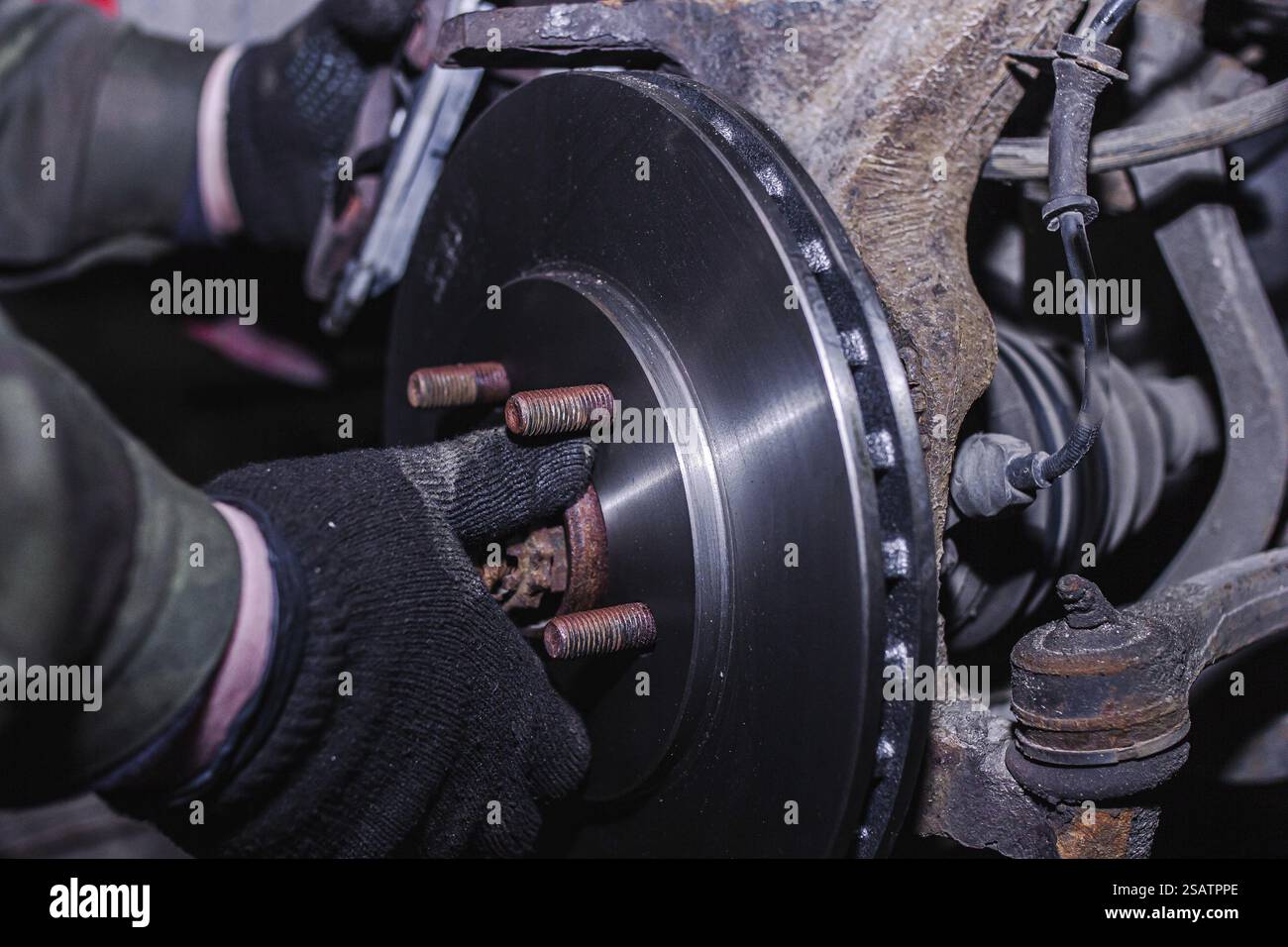 Mechanic's hands adjusting a rotor with dark tones and gloves Stock ...