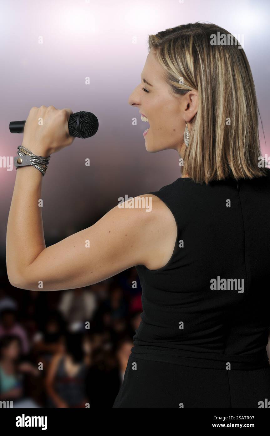 Beautiful woman singer performing at a concert Stock Photo - Alamy