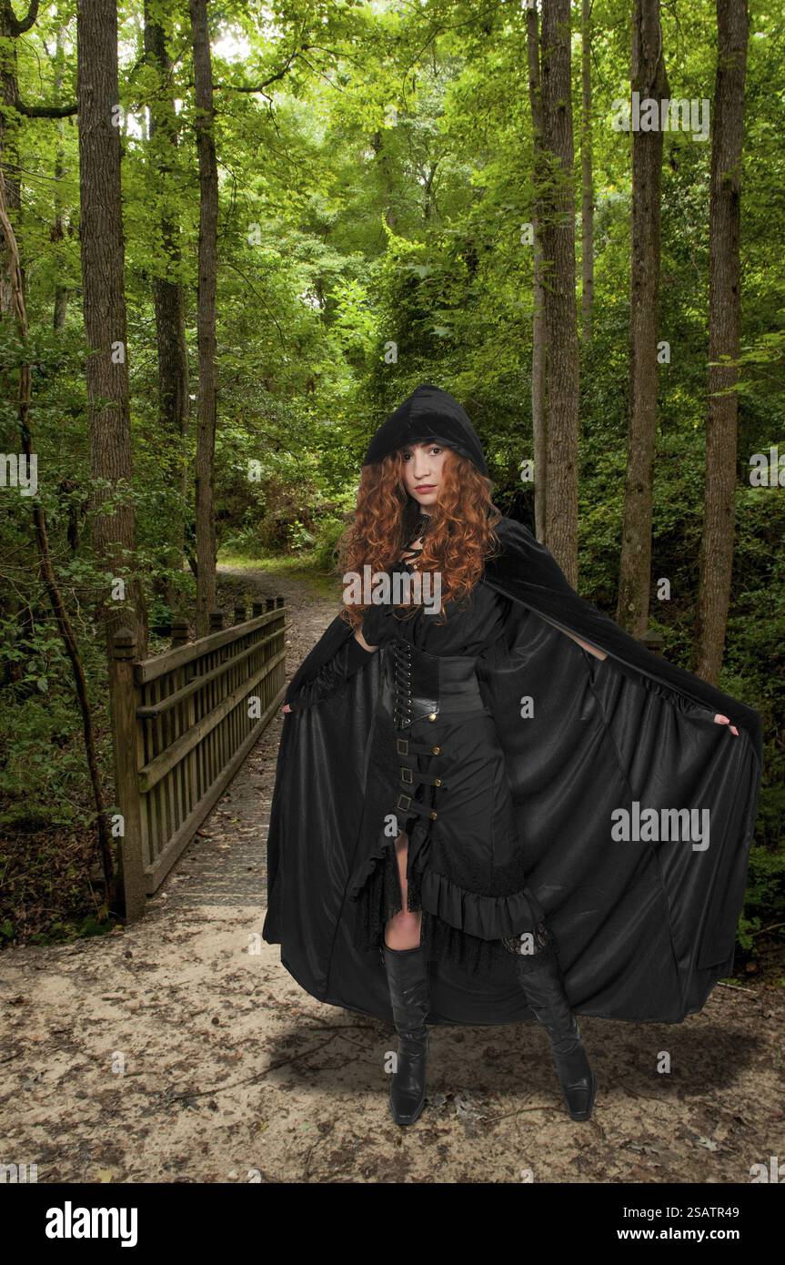 Beautiful woman wearing a long black cloak Stock Photo - Alamy