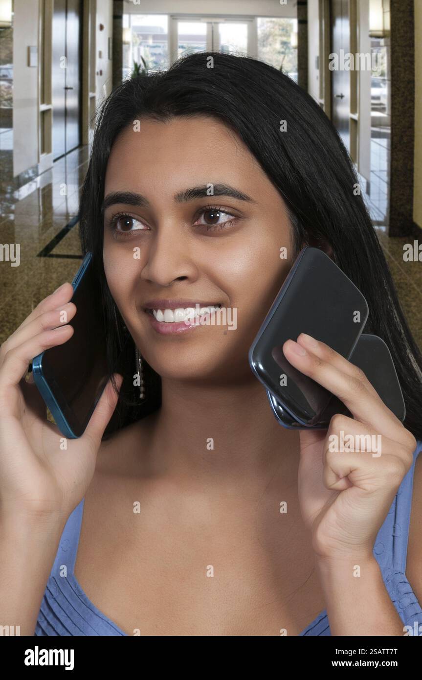 Beautiful woman talking and multitasking while juggling multiple cell ...