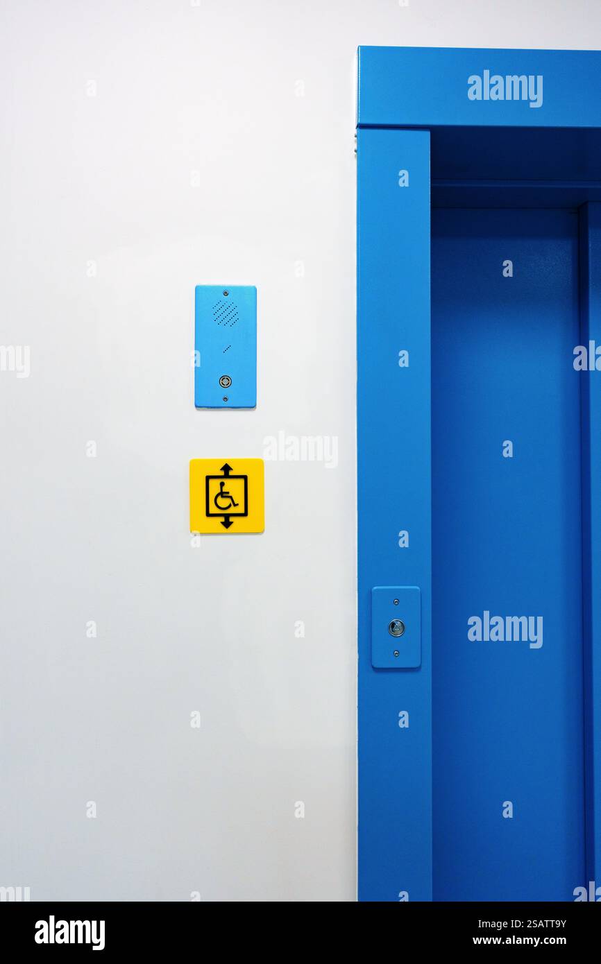 Bright blue elevator entrance features accessibility sign and intercom ... Bright blue elevator entrance features accessibility sign and intercom ...