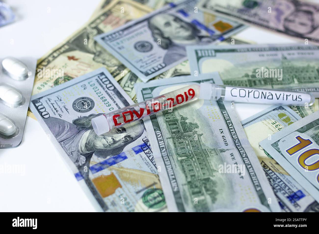 Dollar bills with test tubes labeled COVID-2019 and coronavirus ...