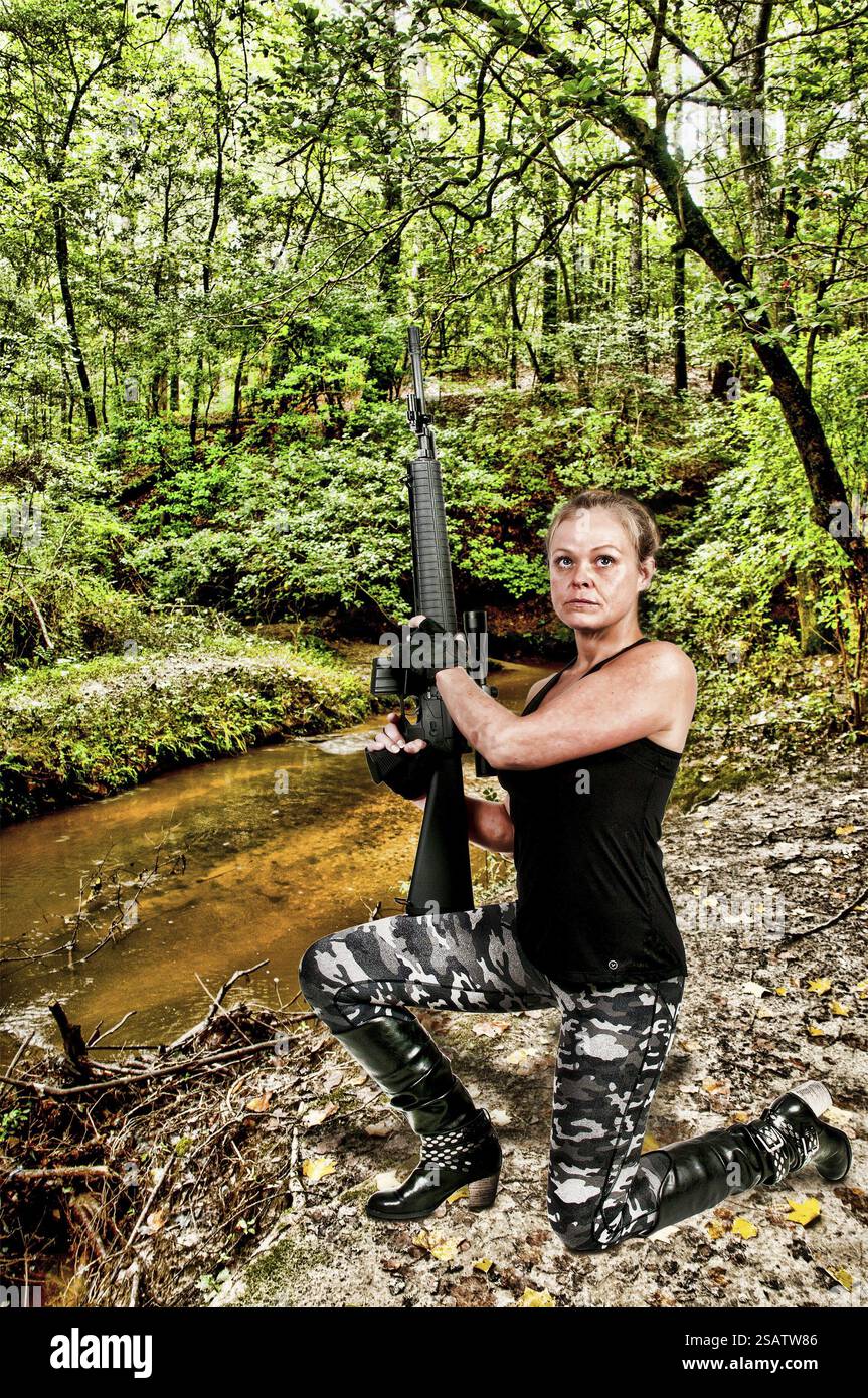 Beautiful young woman holding an automatic assault rifle Stock Photo - Alamy