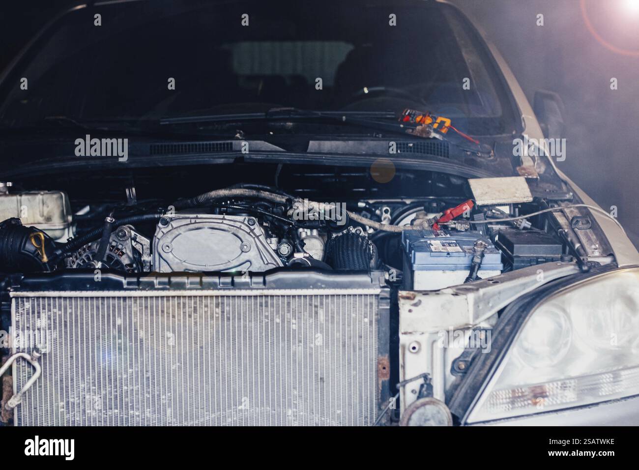 Front view of a car with the engine exposed for repairs, showing ...