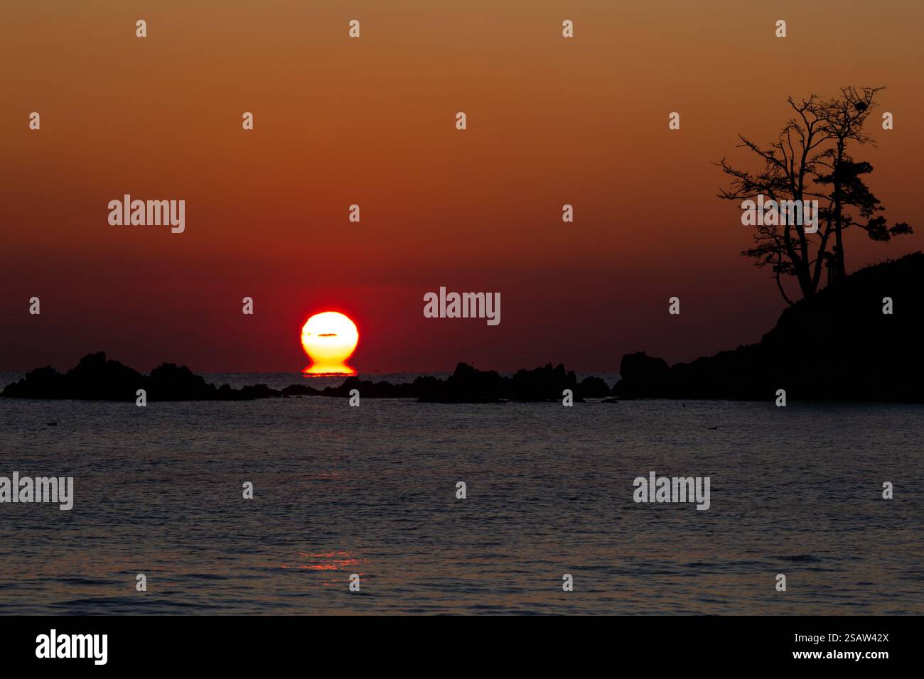 sunrise with a round sun rising behind the island silhouette Stock ...