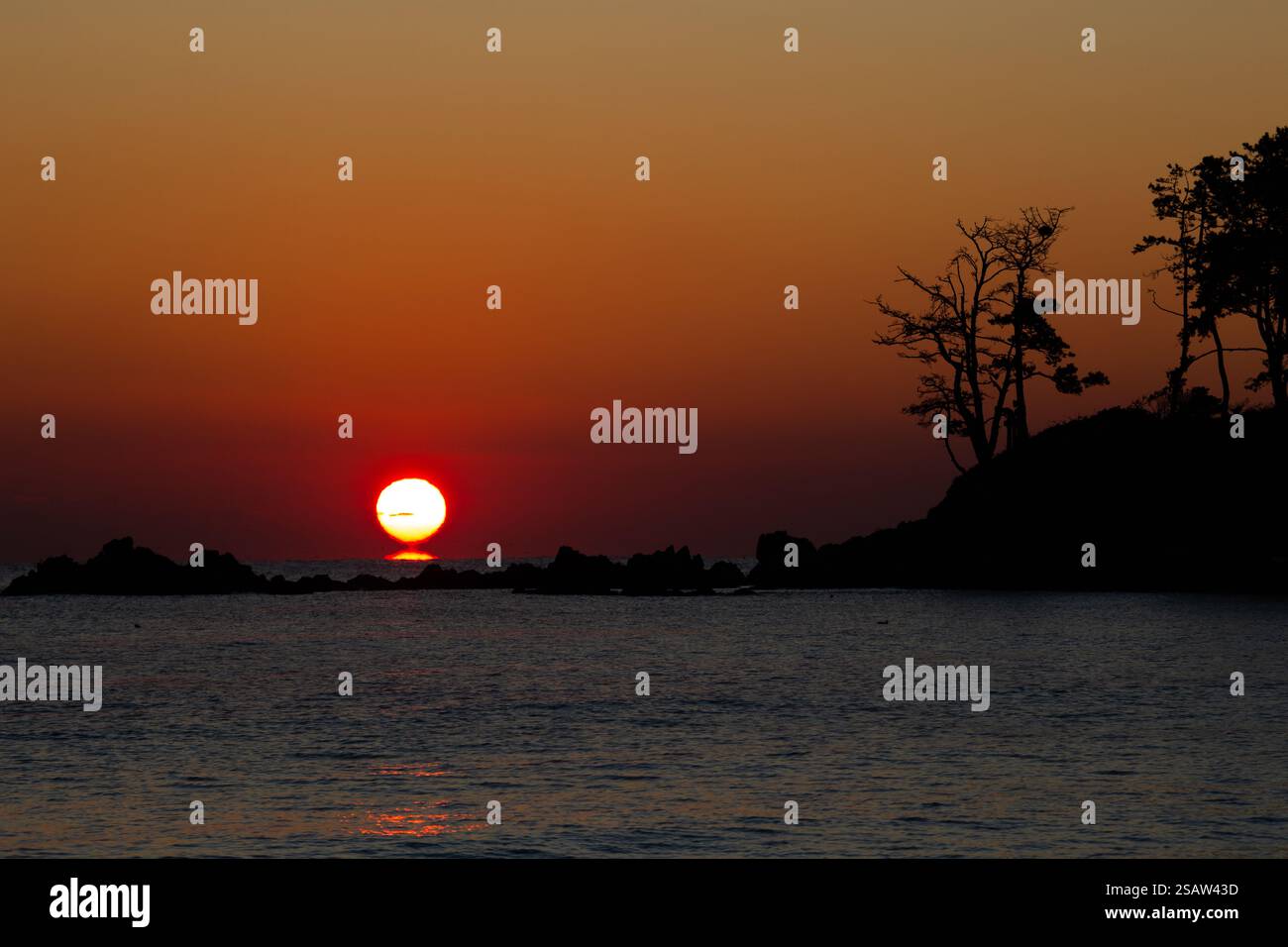 sunrise with a round sun rising behind the island silhouette Stock ...
