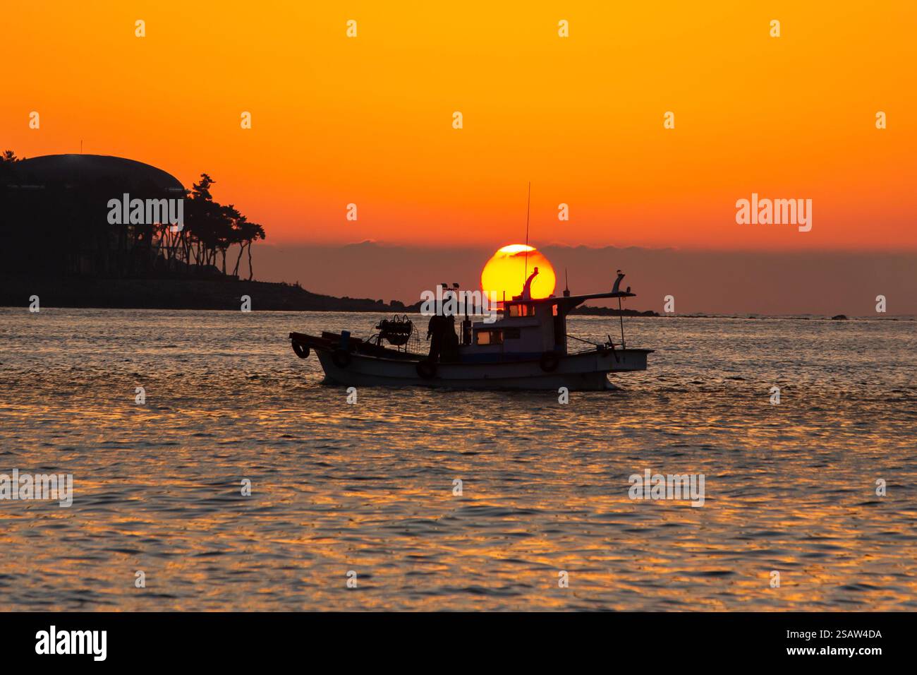 The sea and fishing boats with the red sun rising Stock Photo - Alamy