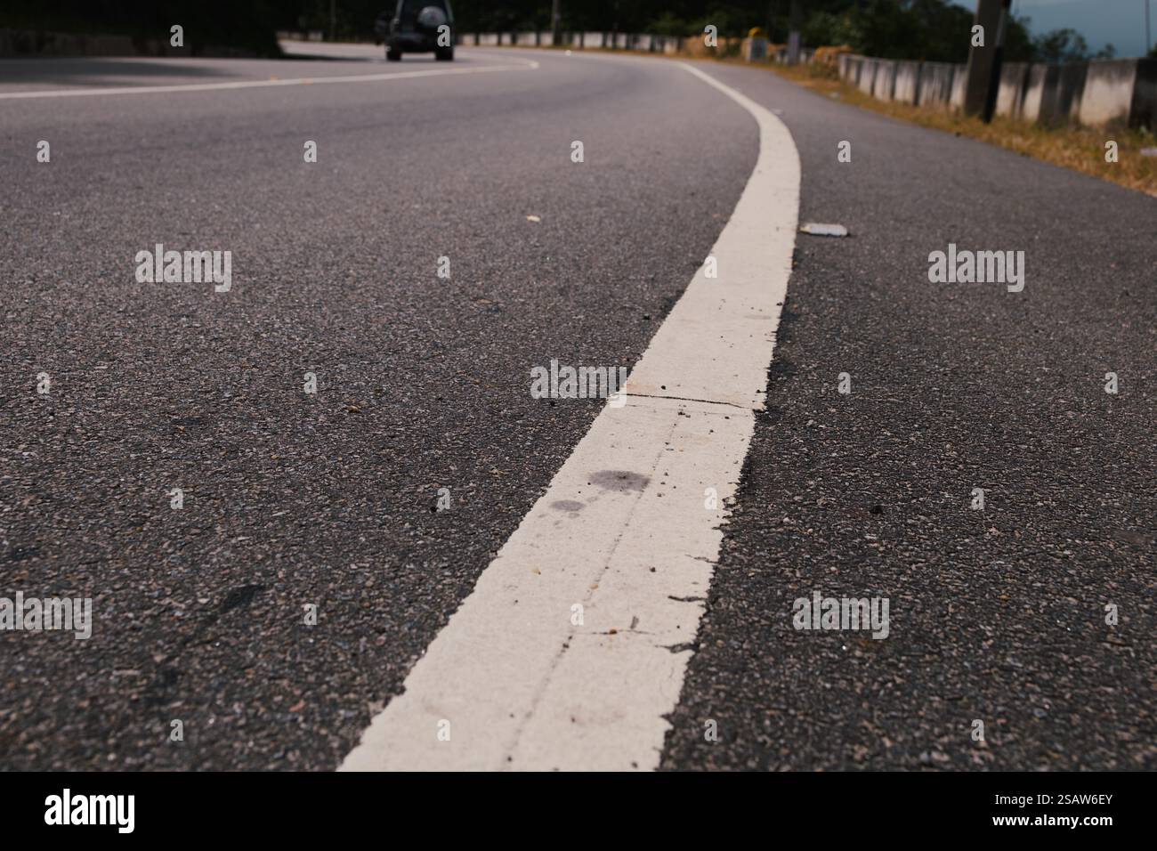 A photo of a straight asphalt road with a white center line. The image ...