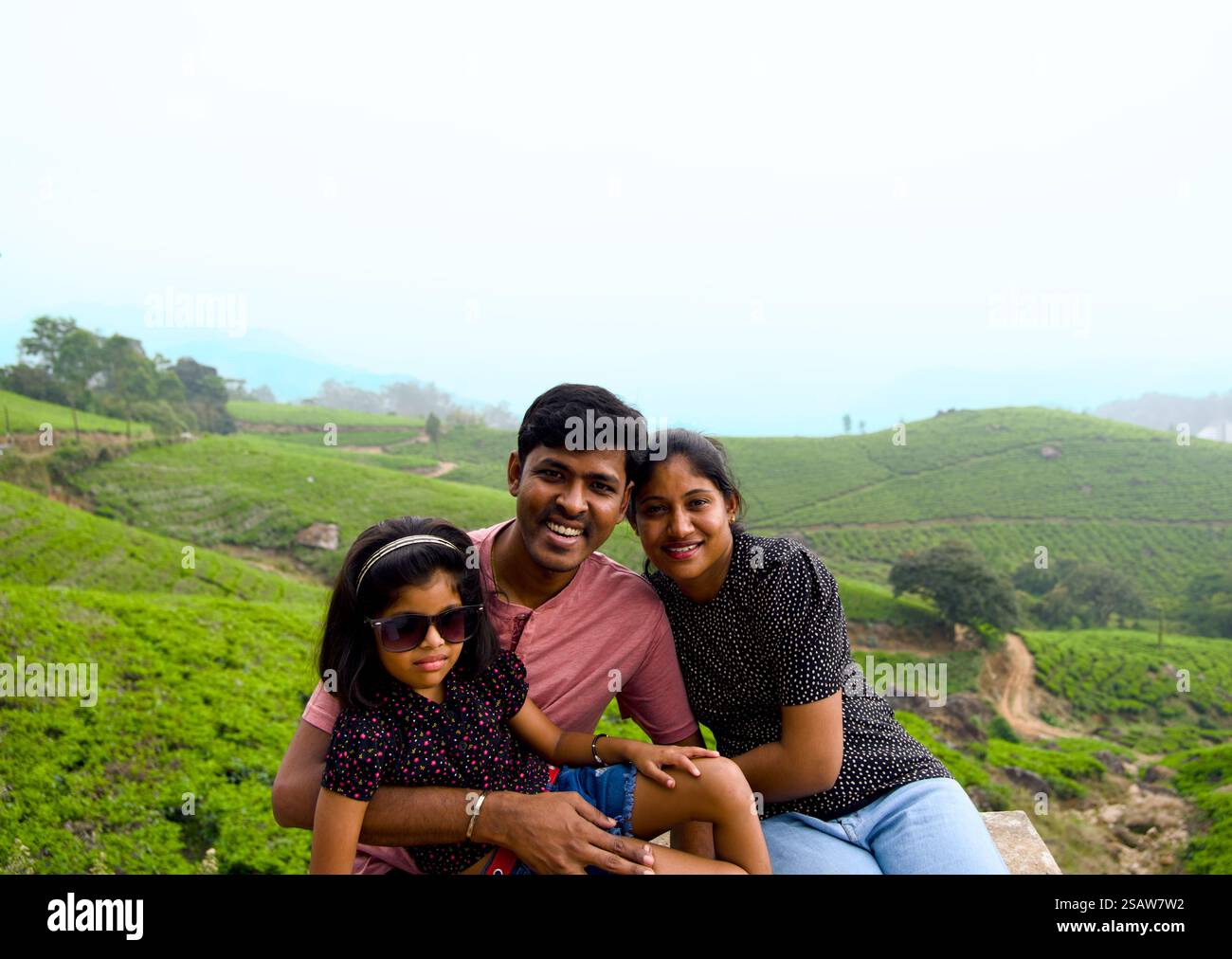 An Indian family enjoys a scenic walk through a lush tea plantation in ...
