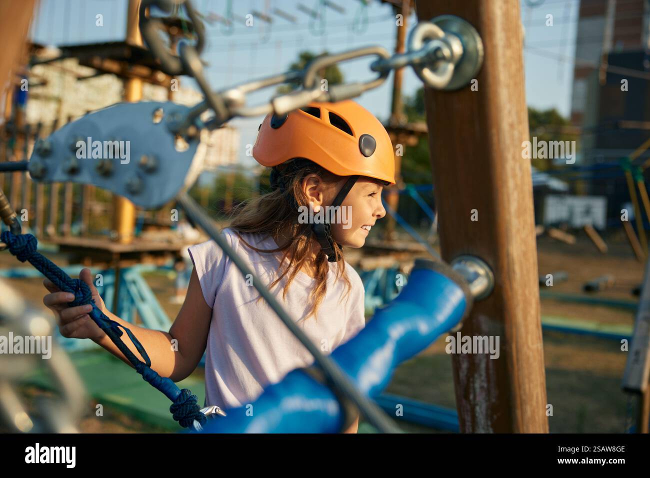 Little girl child overcoming rope obstacle track high in trees in ...