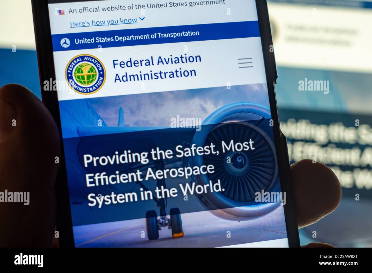 Fingers navigate a smartphone displaying the Federal Aviation ...