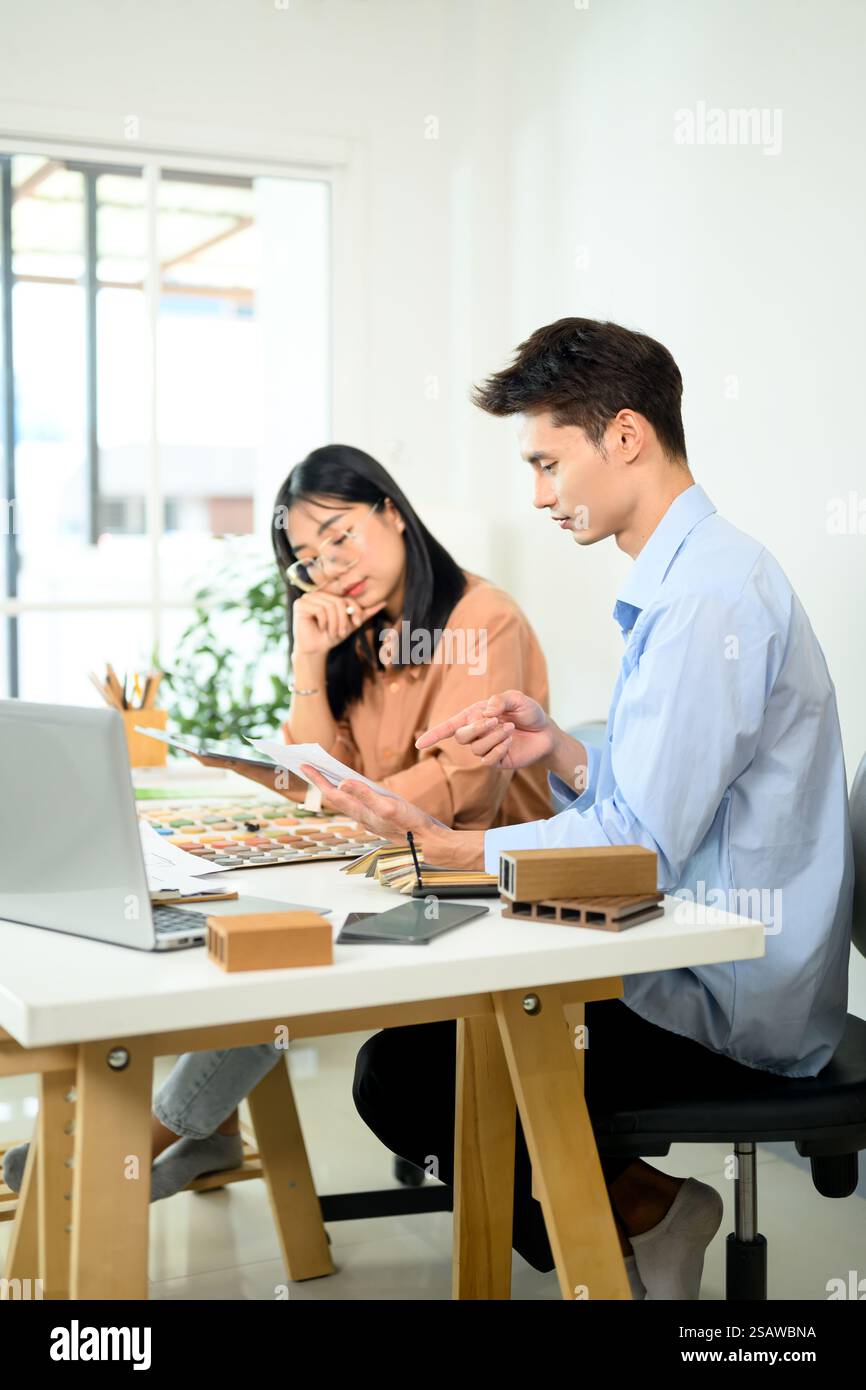 Interior designers collaborating on a project, reviewing material ...