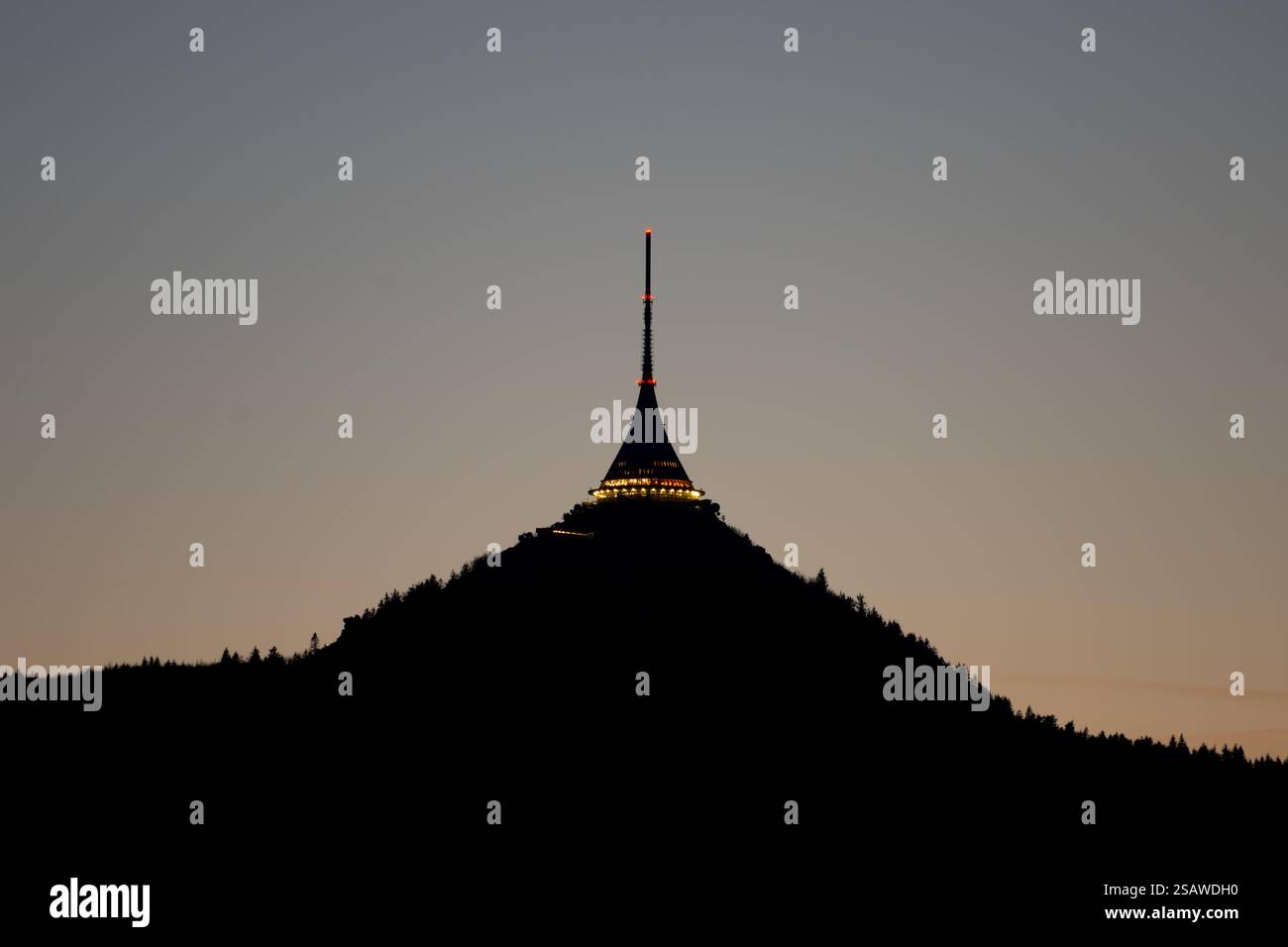 Illuminated against the twilight, Jested Tower towers over Liberec ...