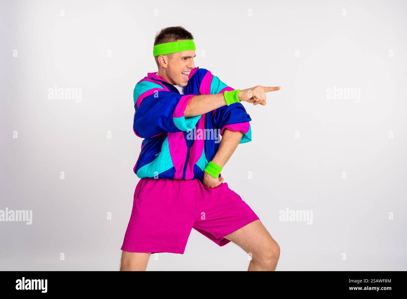 Energetic young man in retro workout attire strikes a dynamic pose ...