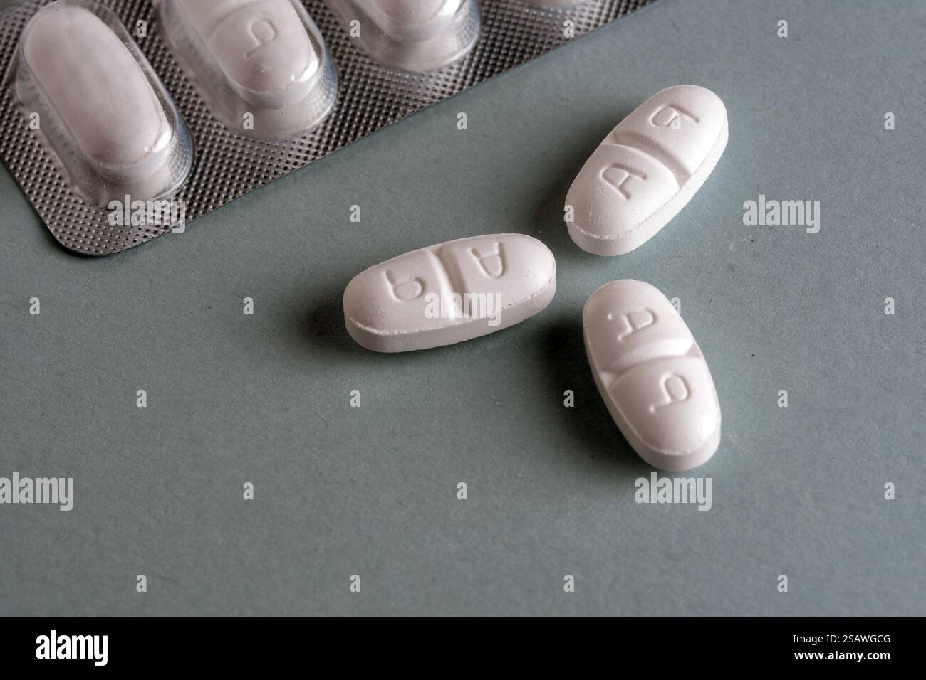 Three white tablets with A9 imprint next to a blister pack. Focus on ...