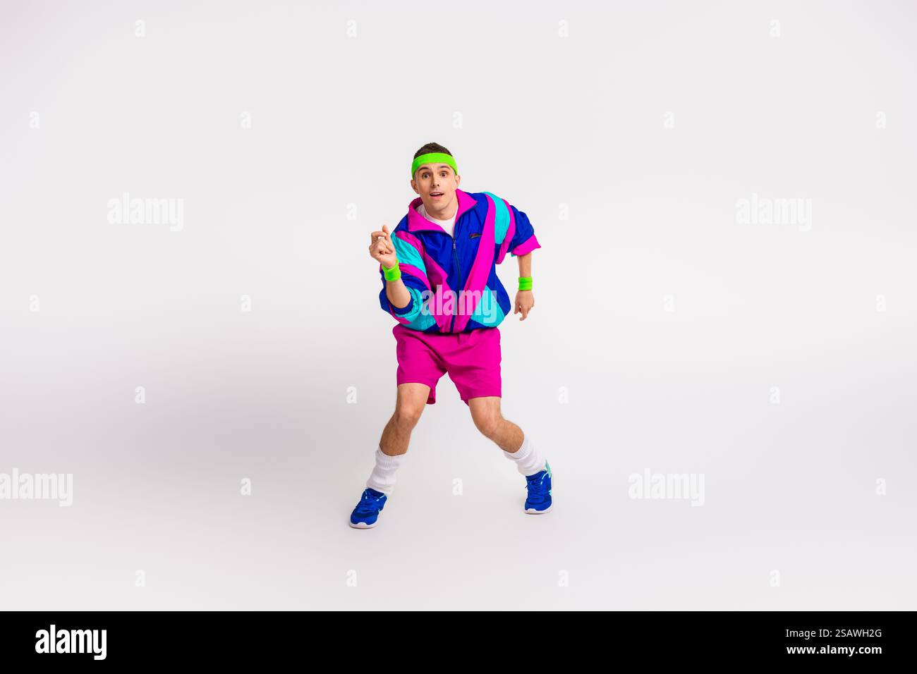 Retro fitness scene with young man in colorful activewear performing ...