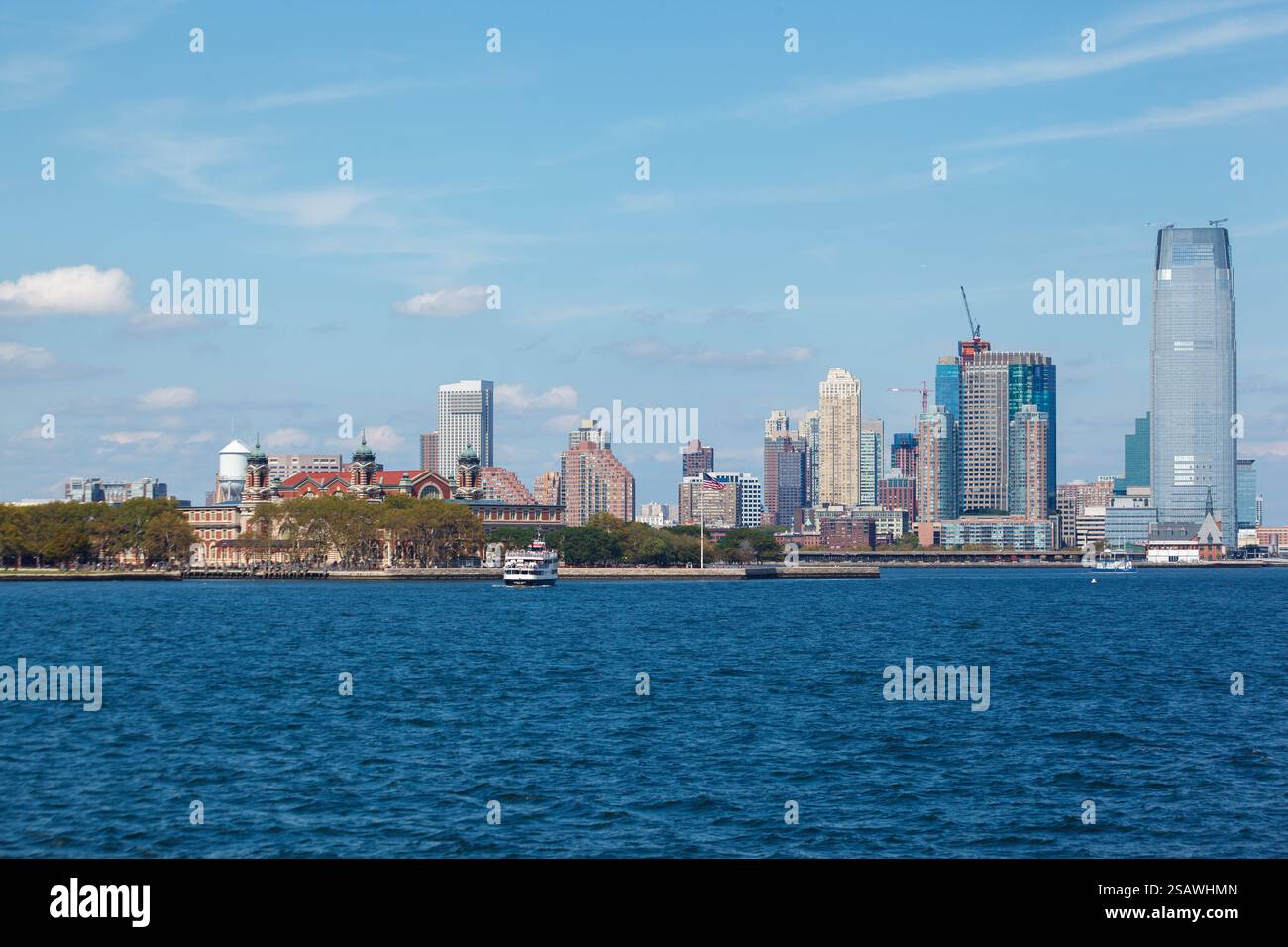 A Tourboat, Ellis Island historical buidling and Goldman Sachs building ...