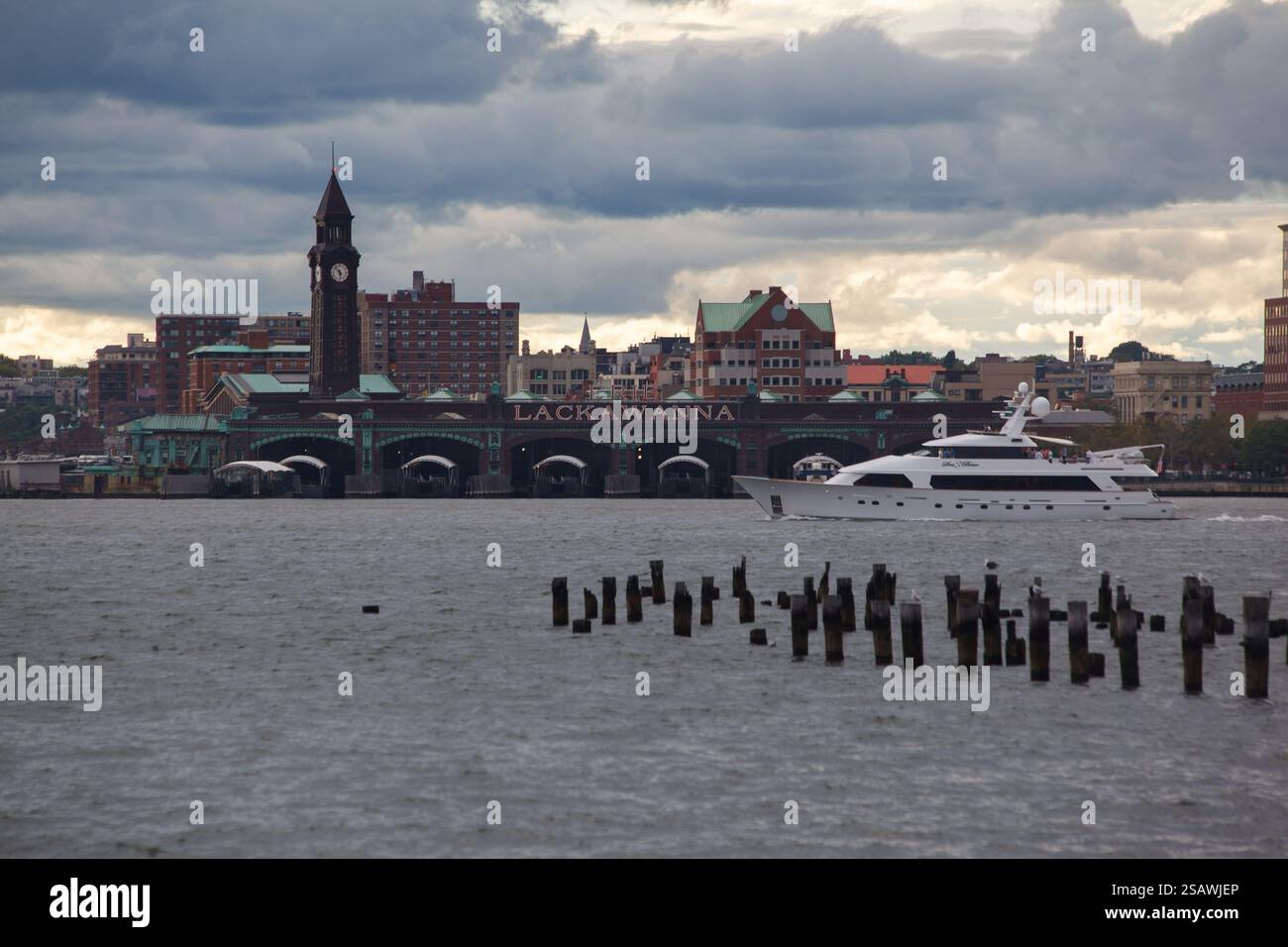 An elegant yacth and Hoboken terminal with its historical clock tower ...