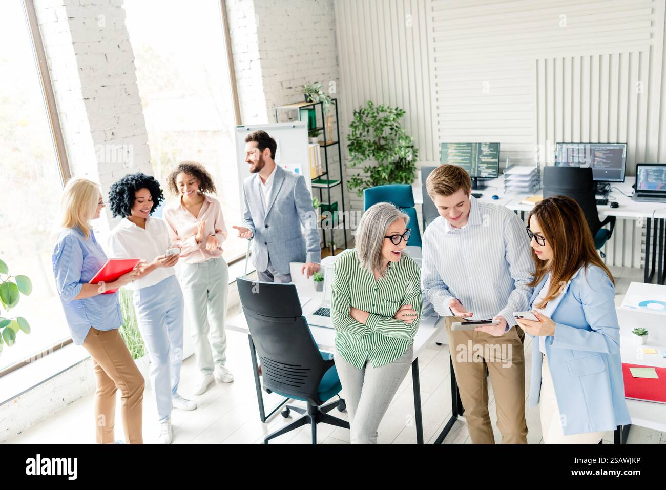 Diverse colleagues collaborating in a modern office space with a ...