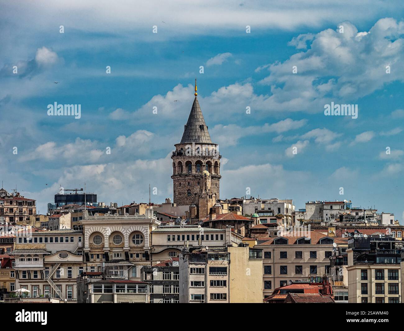 A historic tower stands prominently among urban buildings under a vivid ...