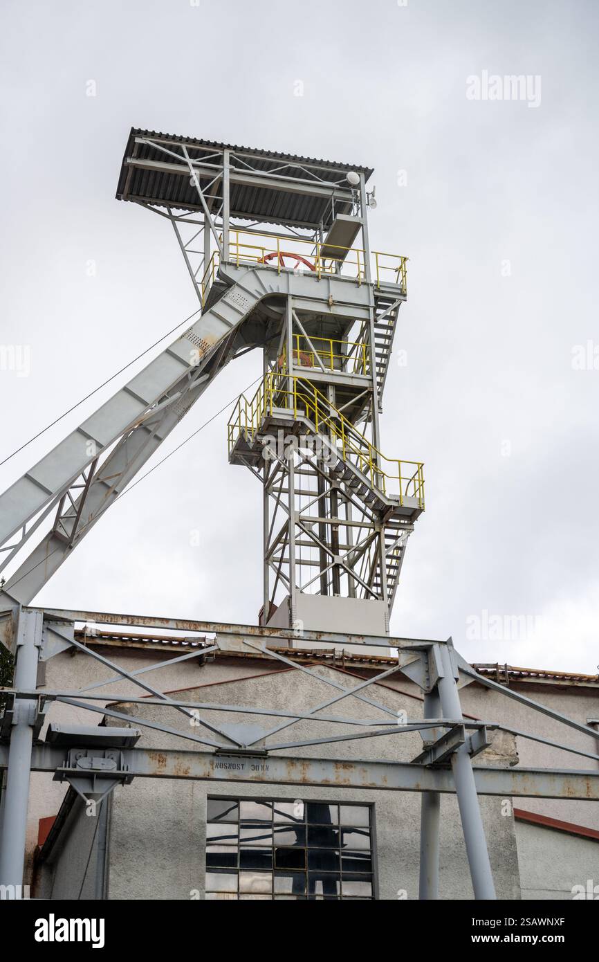 The historic mining tower in Jachymov, Czechia stands against a gray ...