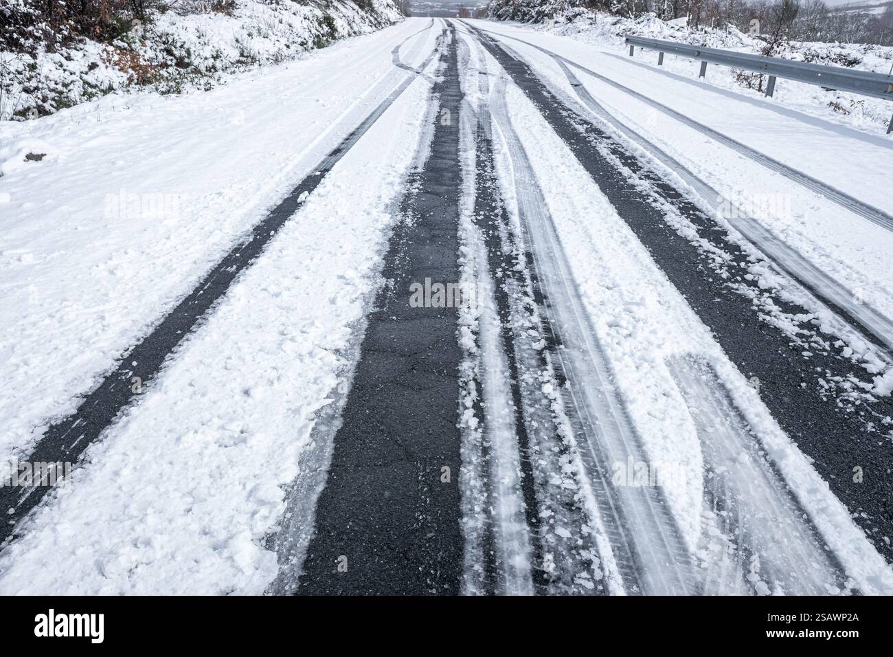 view of a road after a snowfall with tyre marks in the snow Stock Photo ...