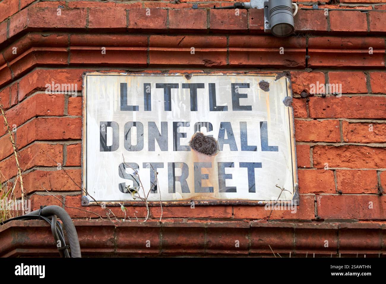 old rusting street sign on red brick wall little donegall street ...