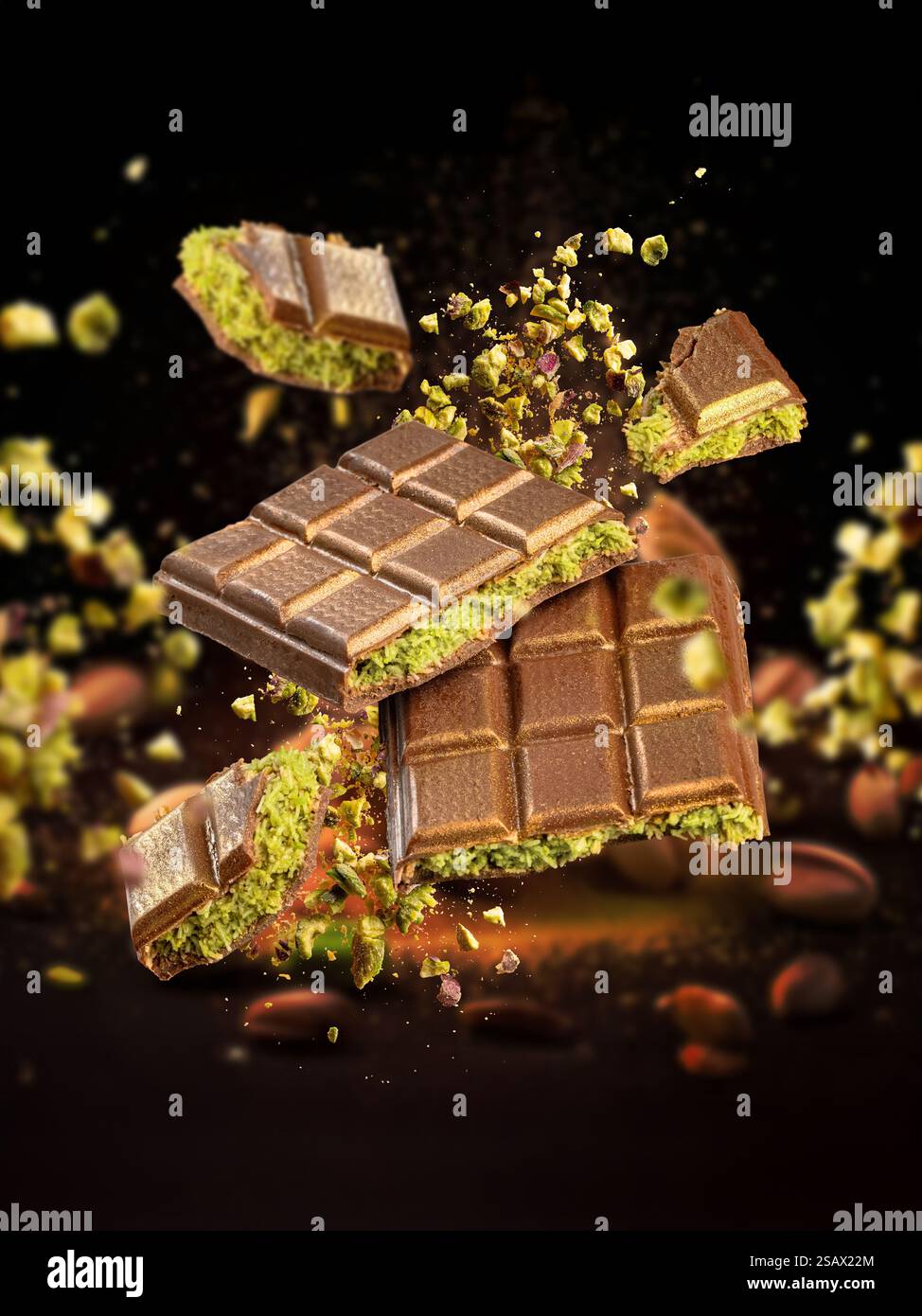 Delicious pistachio chocolate bars and crumbs exploding on a dark ...