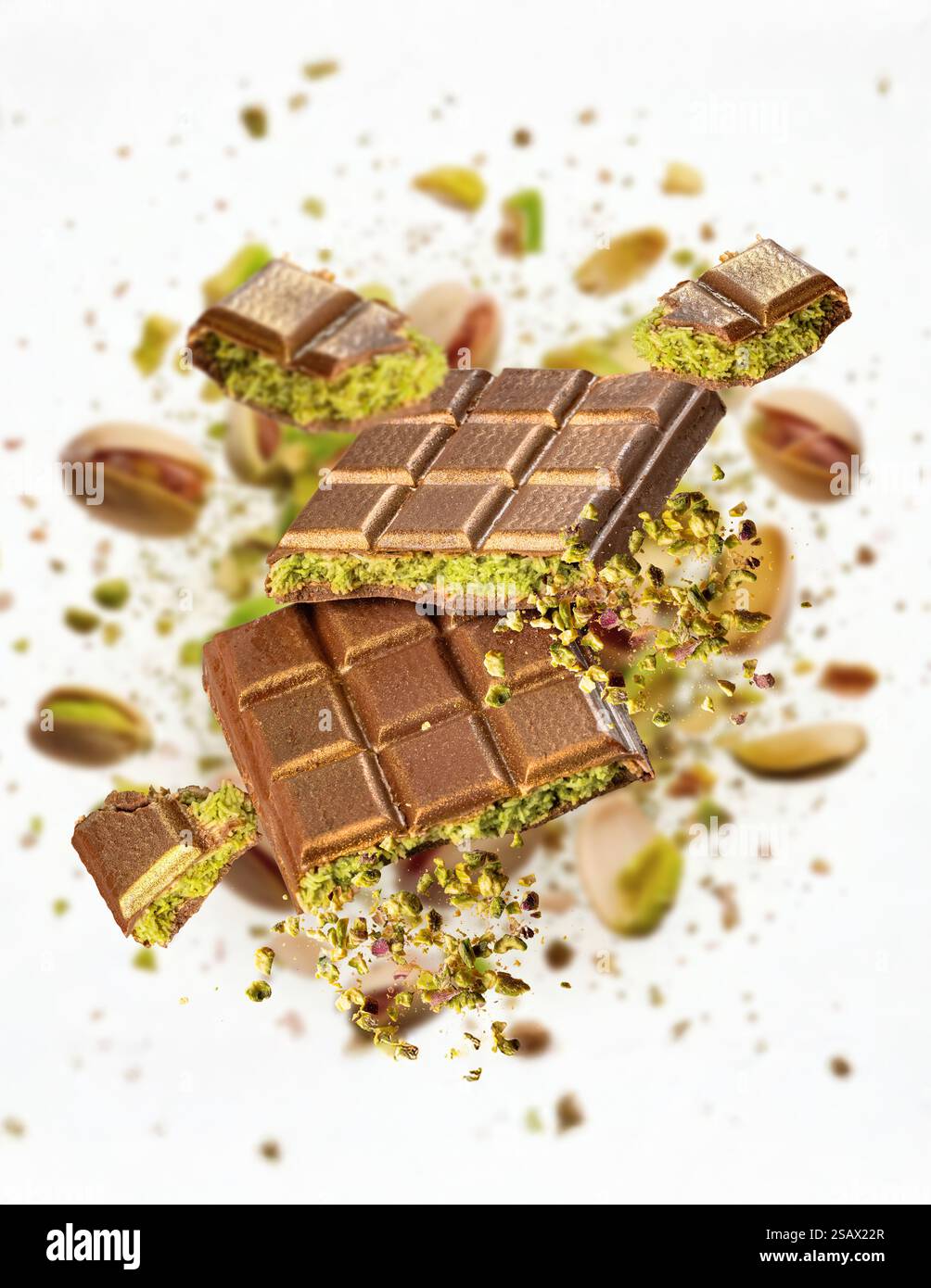Milk chocolate bars with pistachio cream filling exploding on white ...