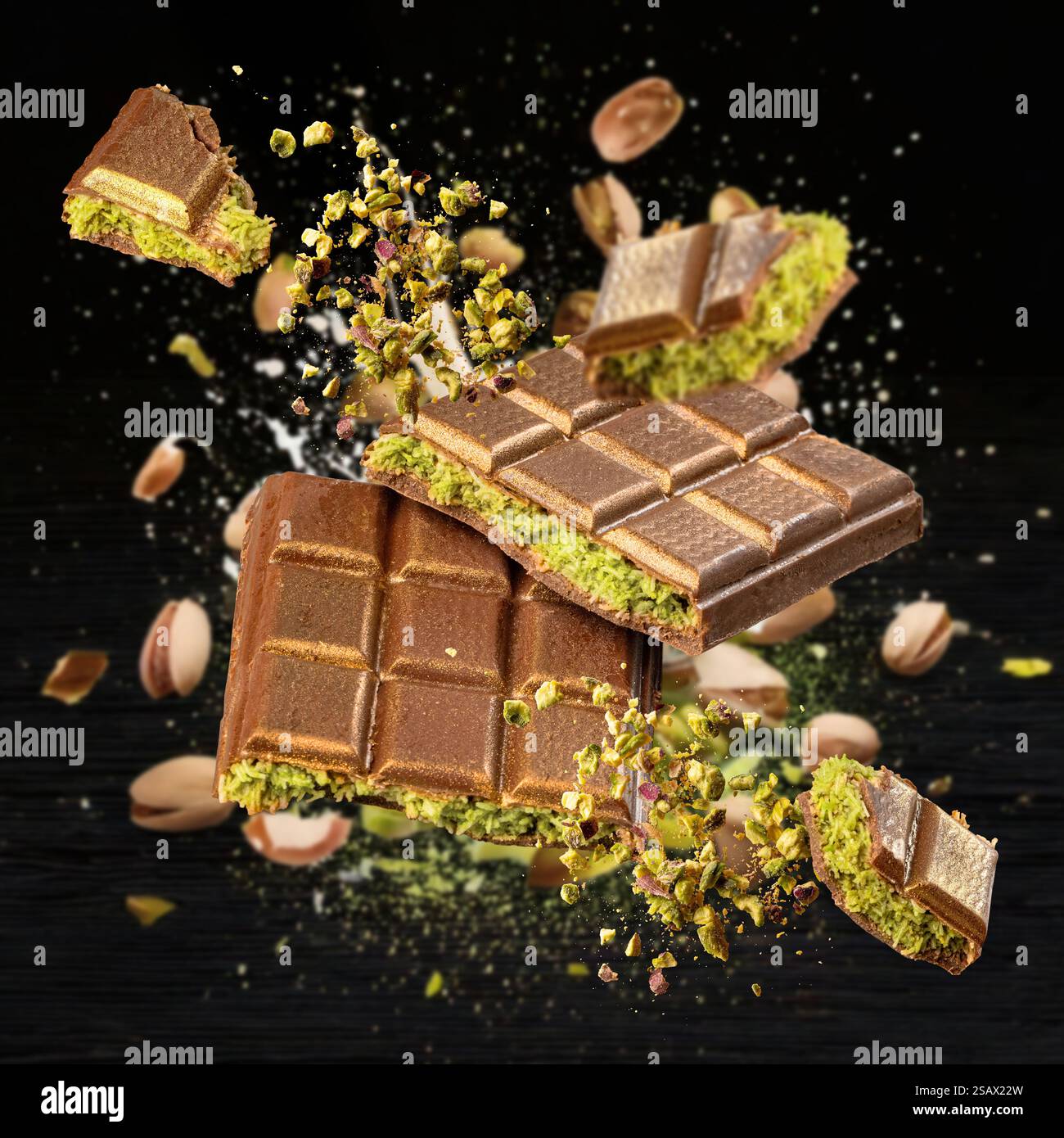 Chocolate bars with pistachio filling exploding on a dark background ...