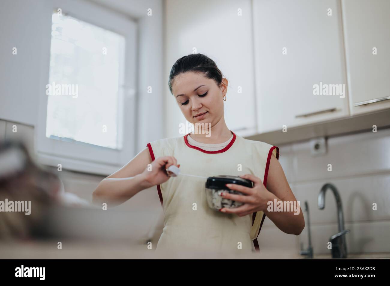 Woman mixing ingredients in kitchen for homemade recipe Stock Photo - Alamy