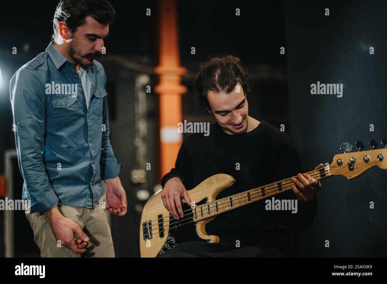 Two individuals practice music in a rehearsal setting, with emphasis on ...