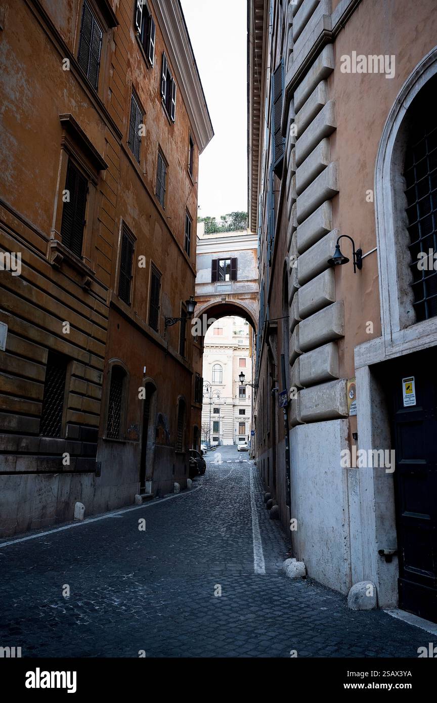 A narrow cobblestone alley in Rome with an arched passageway Stock ...