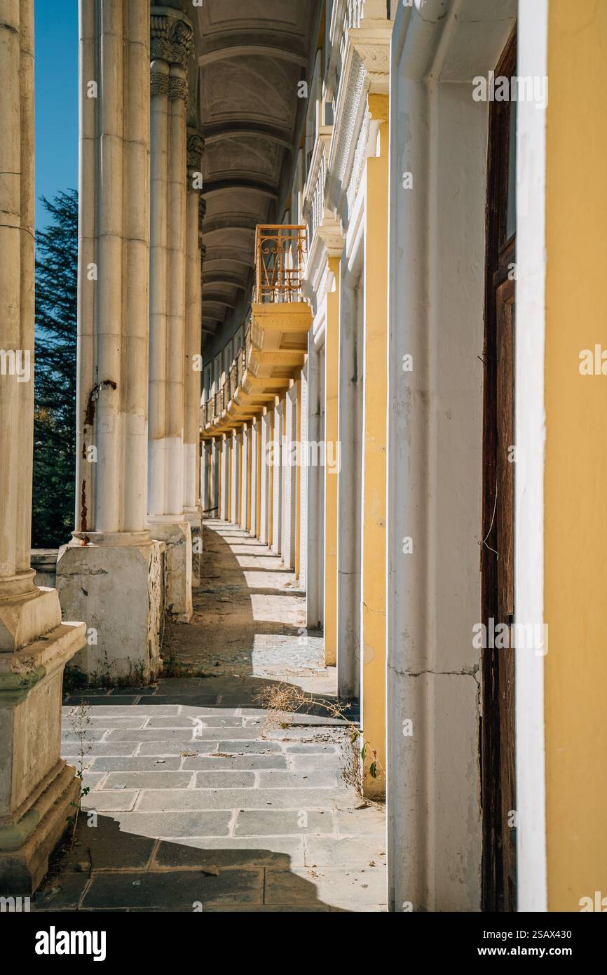 Abandoned colonnade of neoclassical building with tall columns, arched ...