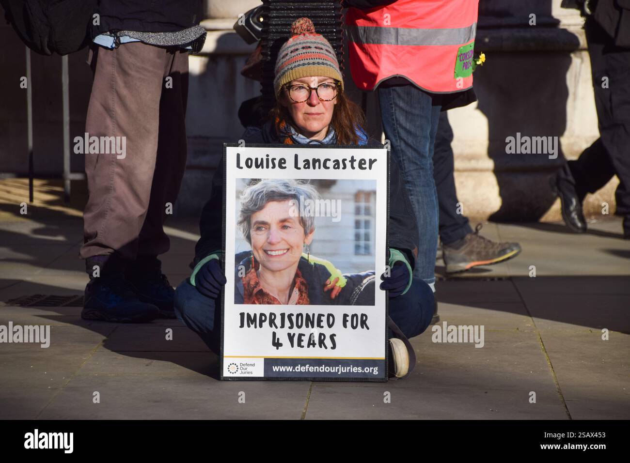 London, UK. 30th January 2025. A protester sits with a picture of ...