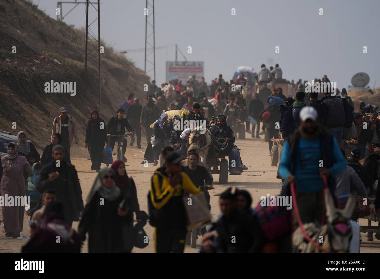 Displaced Palestinians walk on a road in central Gaza to return to ...