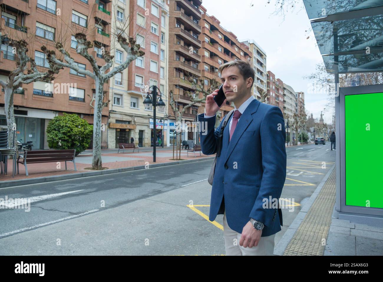 Young man using mobile phone at bus stop hi-res stock photography and ...