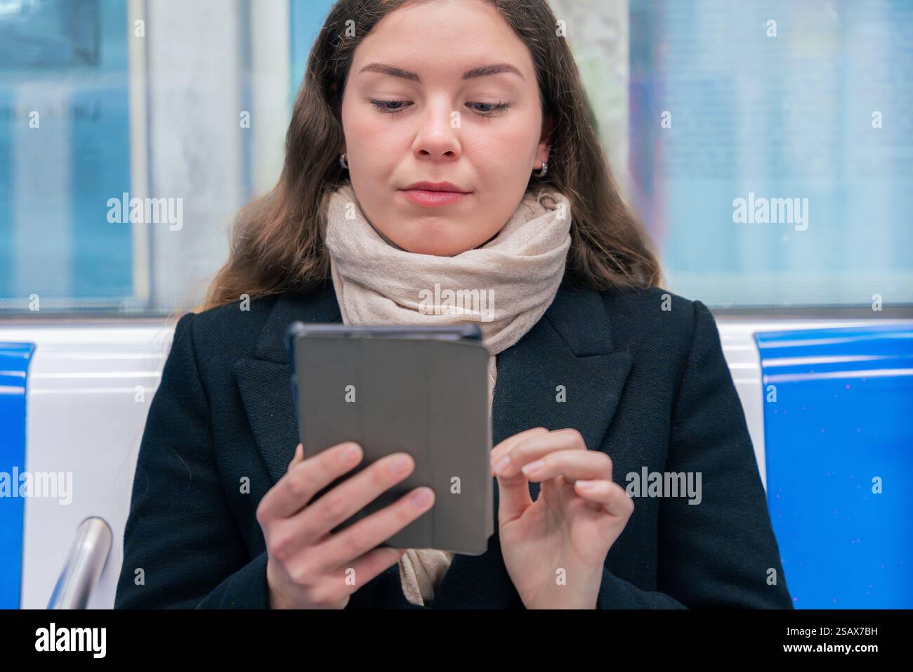 Young Woman Reading on E-Reader While Commuting on Subway Train Stock ...