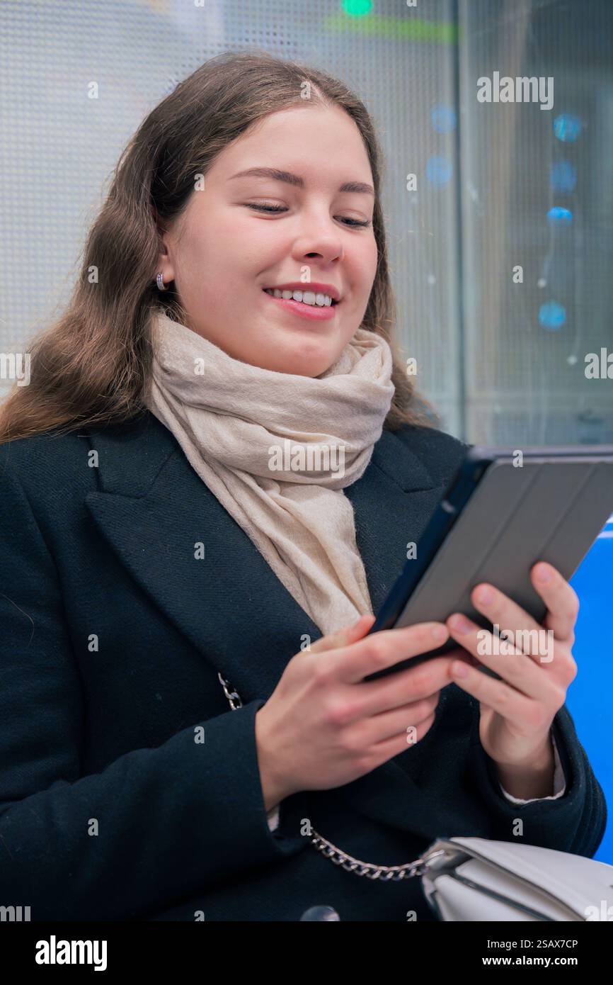 Young Woman Reading on E-Reader While Commuting on Subway Train ...