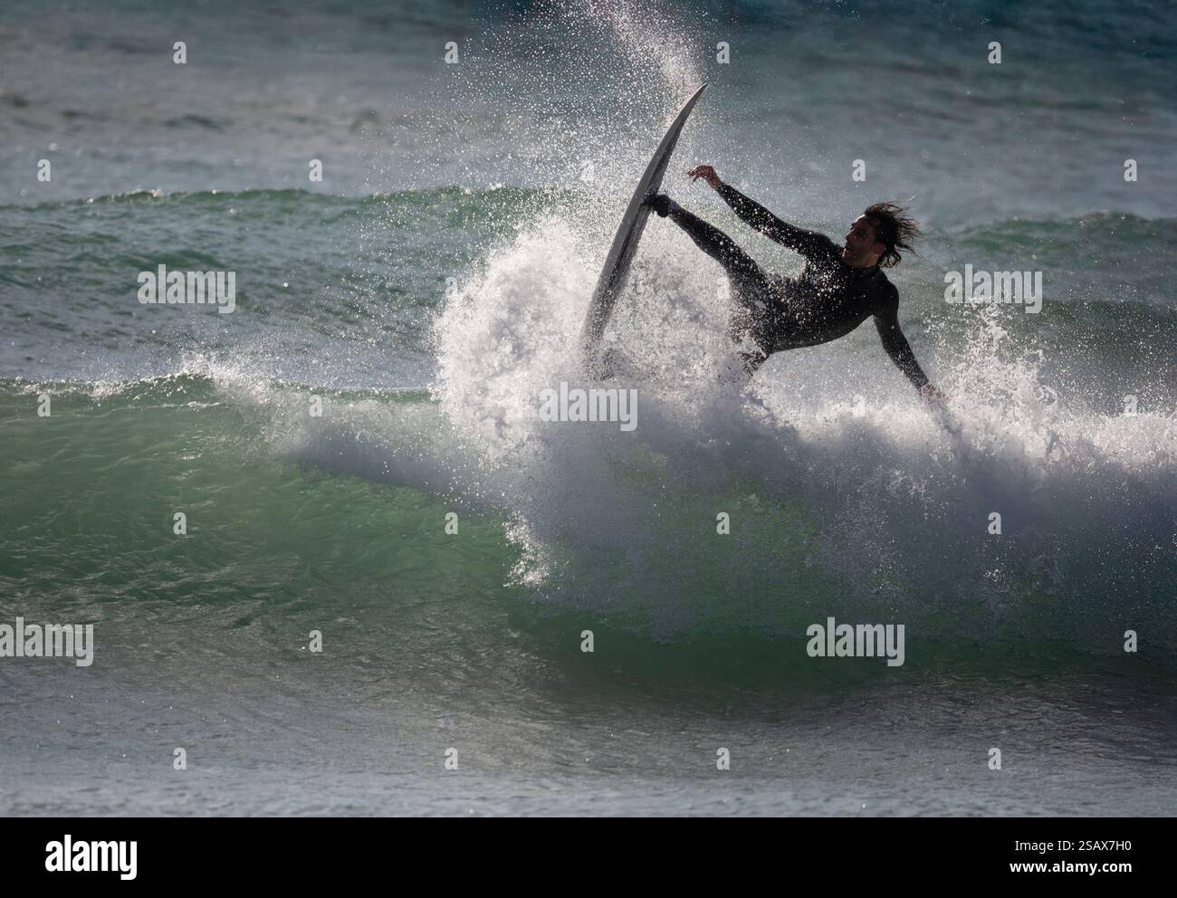 Surfer performing trick on ocean wave Stock Photo - Alamy