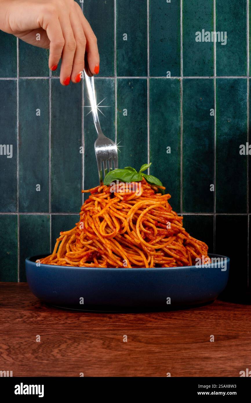 A fork piercing a tower of spaghetti pasta and tomato sauce Stock Photo ...