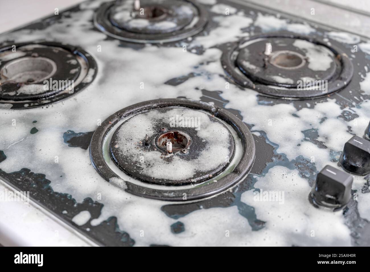 Cleaning a gas stove with kitchen utensils, household concepts, or ...