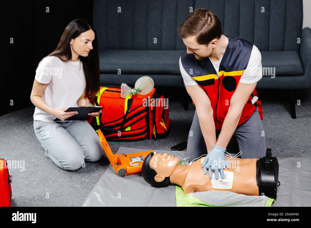 Instructor demonstrating cpr chest compression on a dummy in class Stock Photo - Alamy