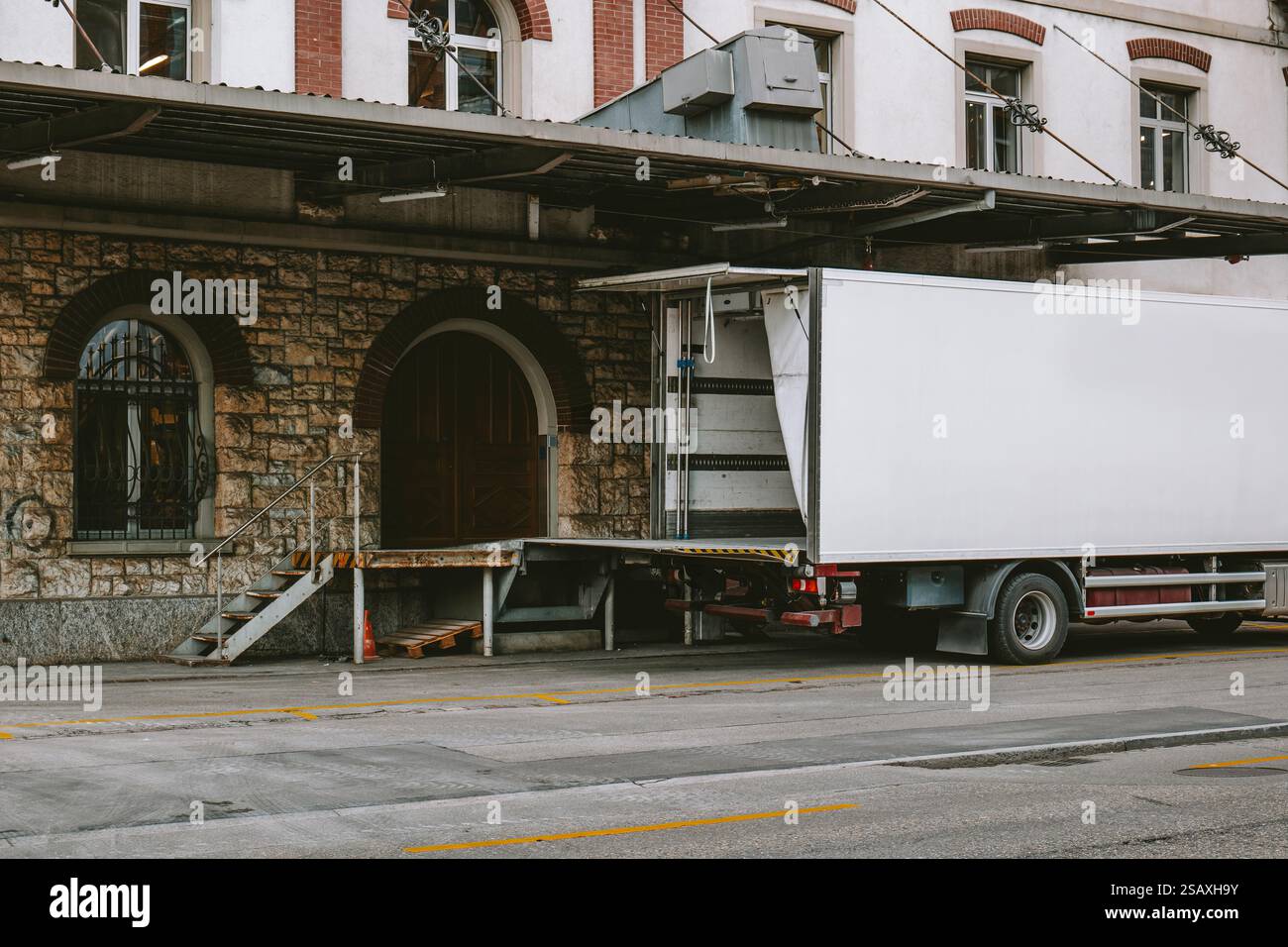Small transport truck with empty and open container door and lift next ...