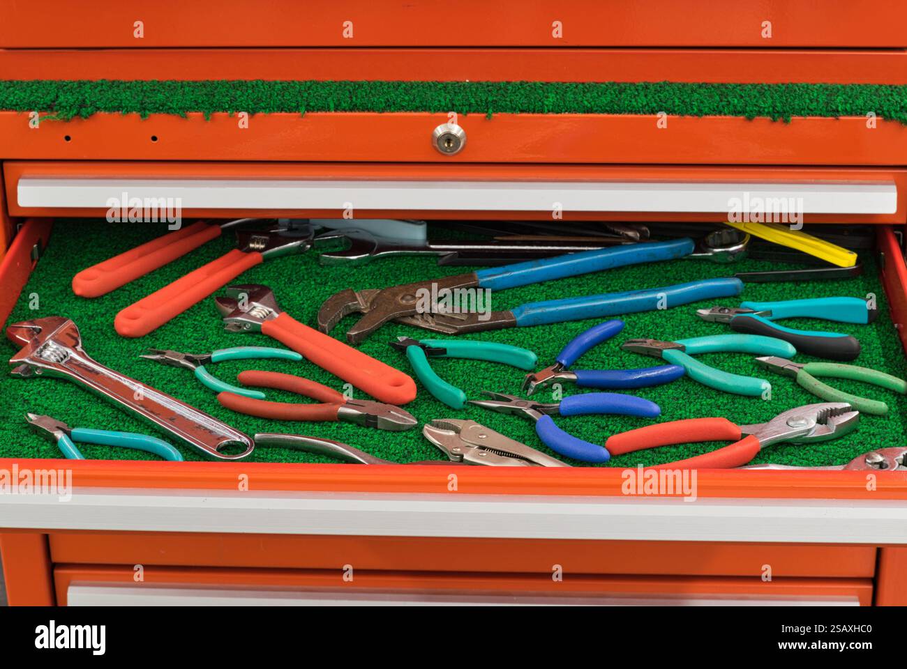 Assorted pliers wrench clamping tools displayed in open toolbox drawer ...