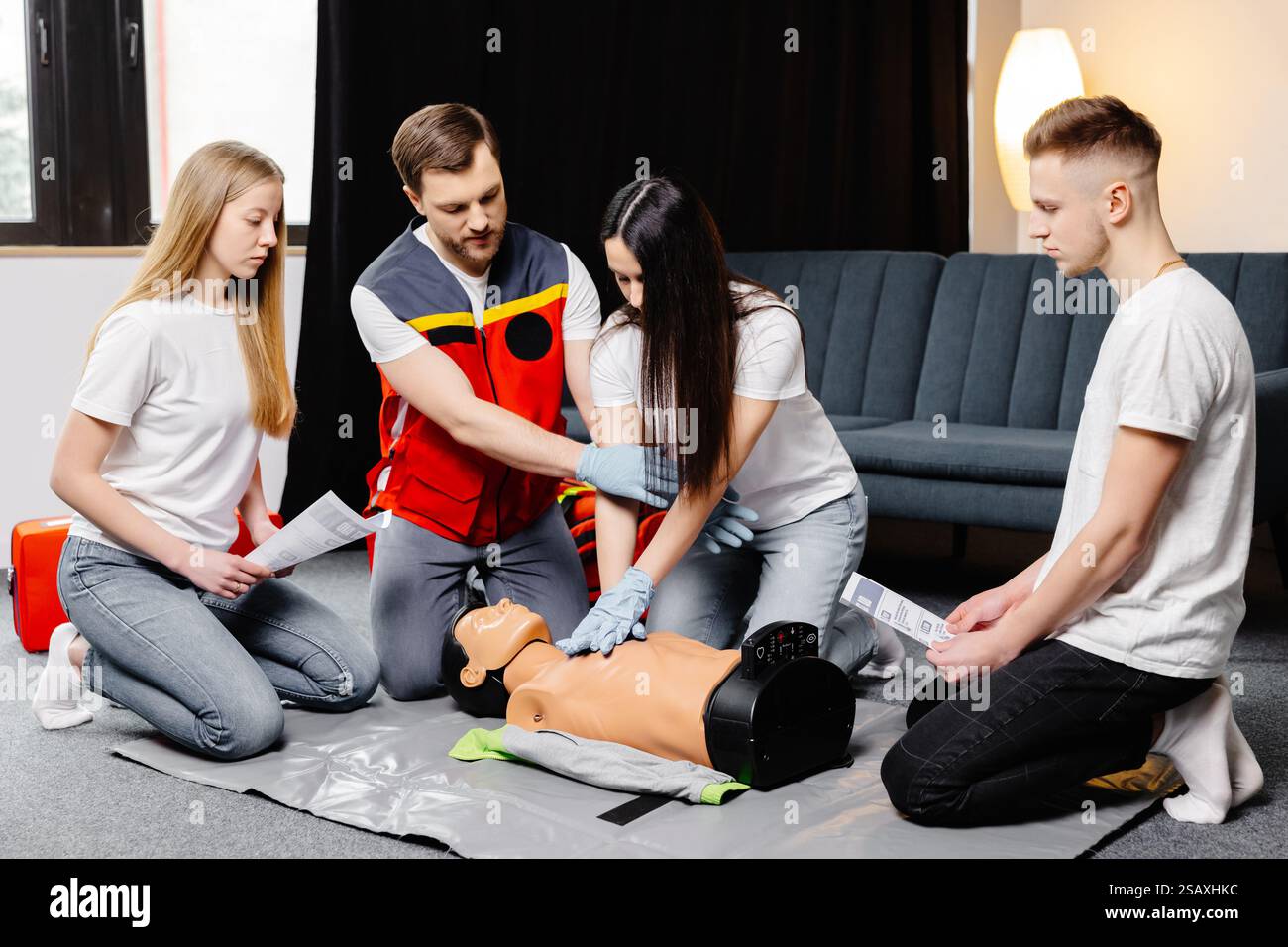 Group of people learning how to make first aid heart compressions with ...
